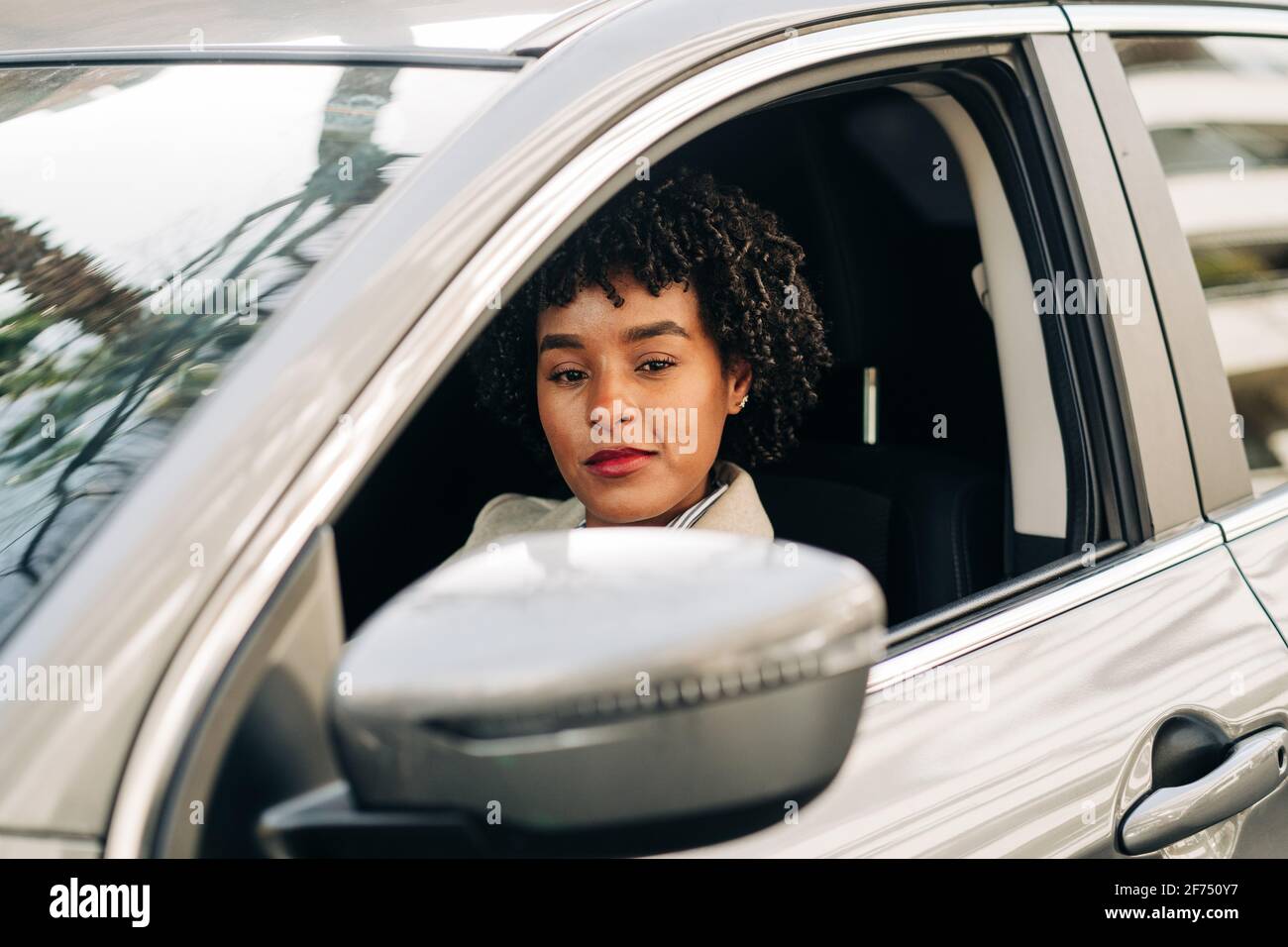 Side view of serious African American female driver in fashionable ...