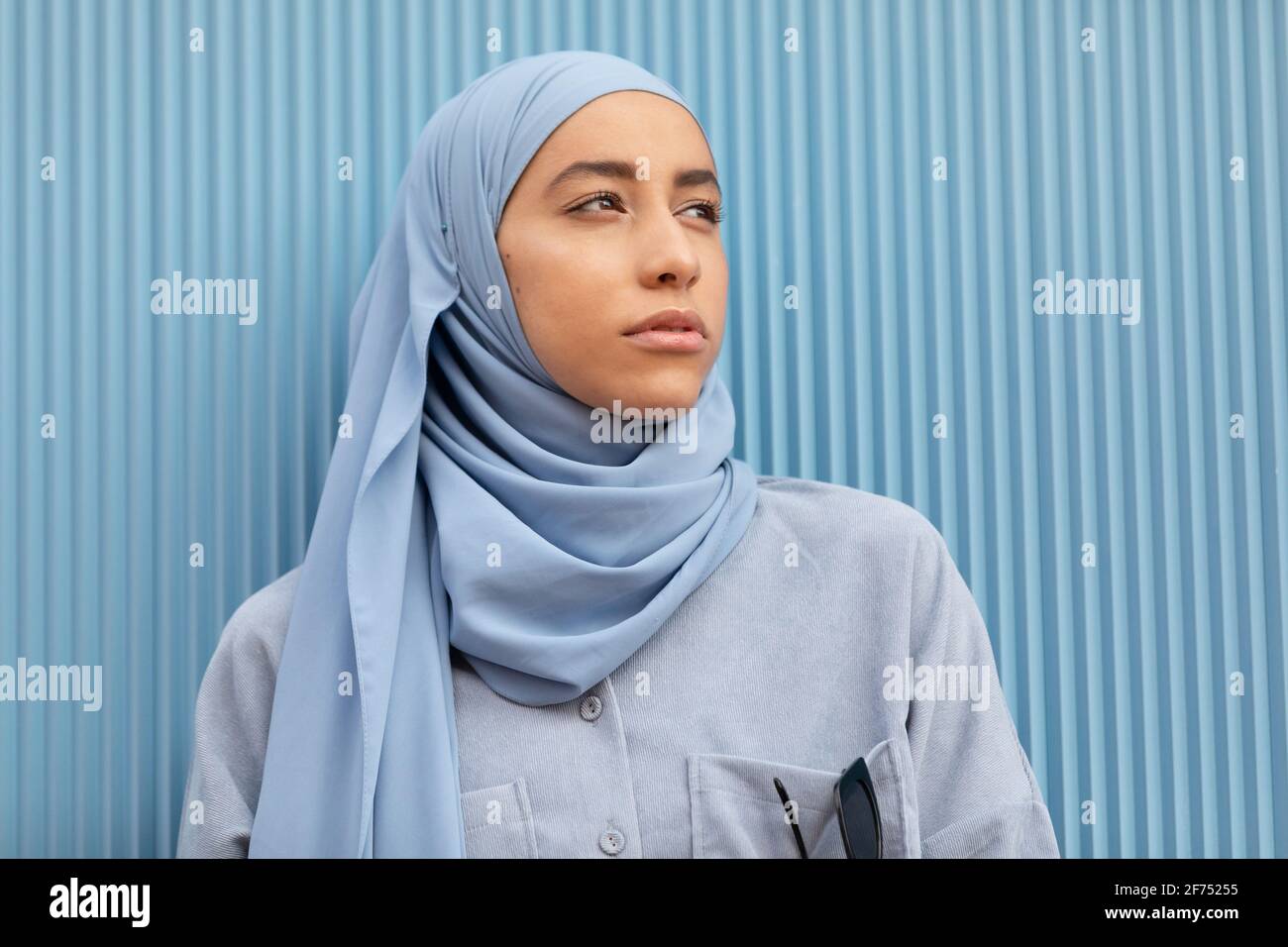 Side view of adult male in sunglasses adjusting saddle on mare back in ...