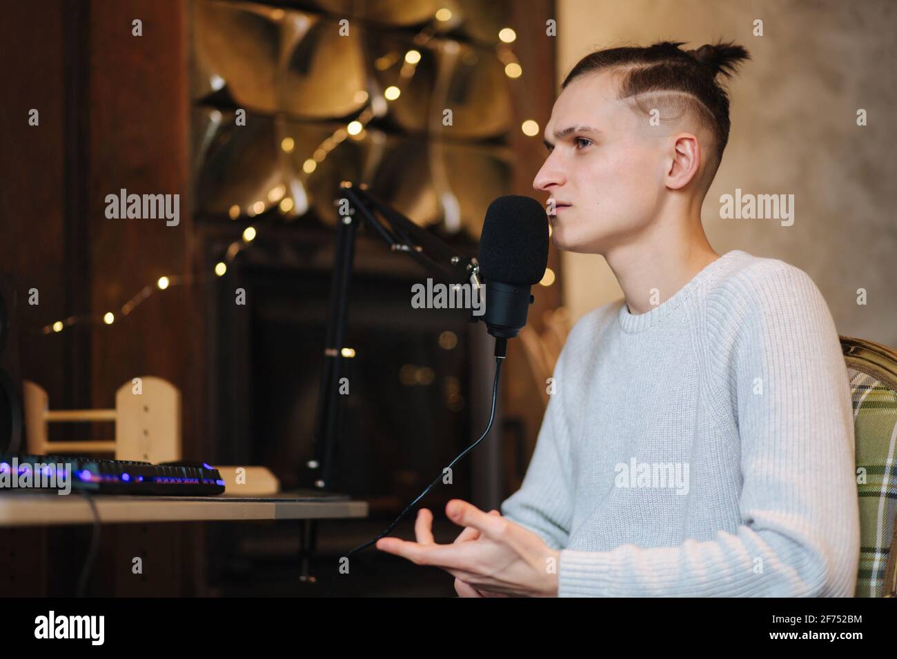 Young man makes a podcast audio recording at home. Man using pc and two ...