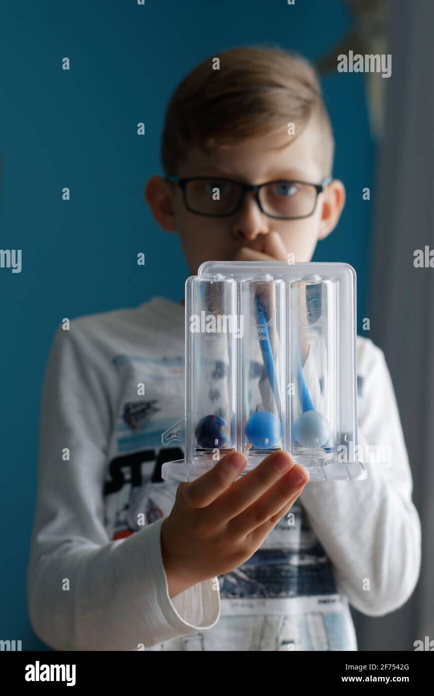 Young boy breaths deep exercise with incentive spirometer. Threeflow ...
