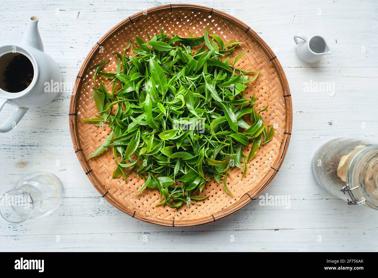 Green tea leaves in a wooden tray And tea in a bottle Stock Photo - Alamy