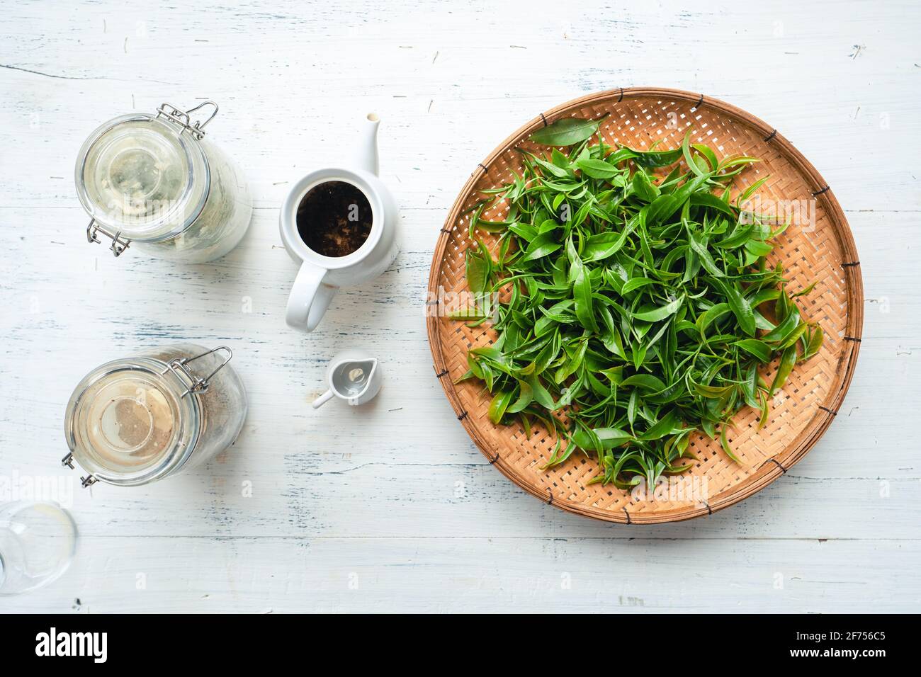 Green tea leaves in a wooden tray And tea in a bottle Stock Photo - Alamy