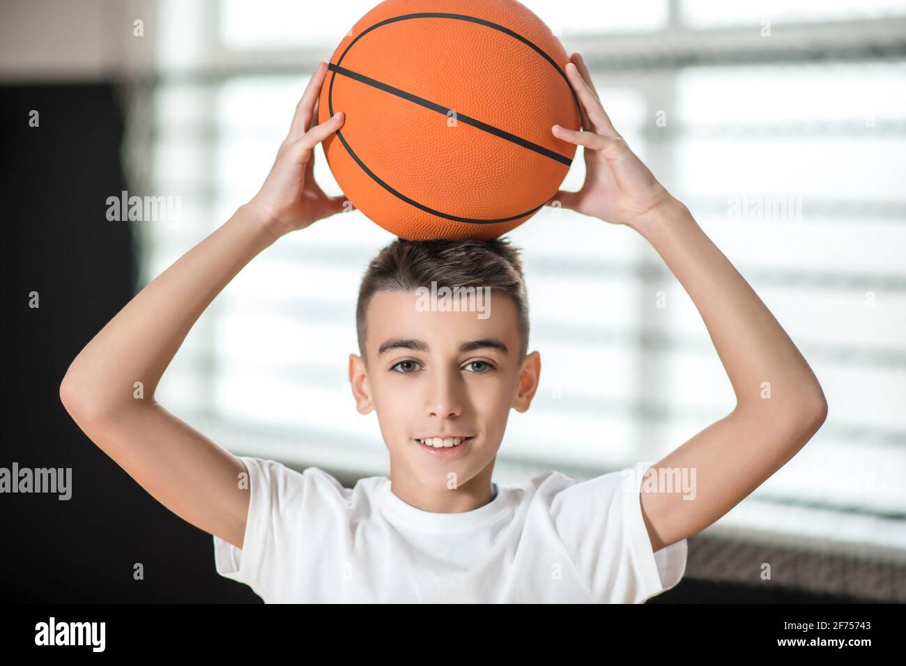 A cute boy with a ball feeling good and contented Stock Photo - Alamy