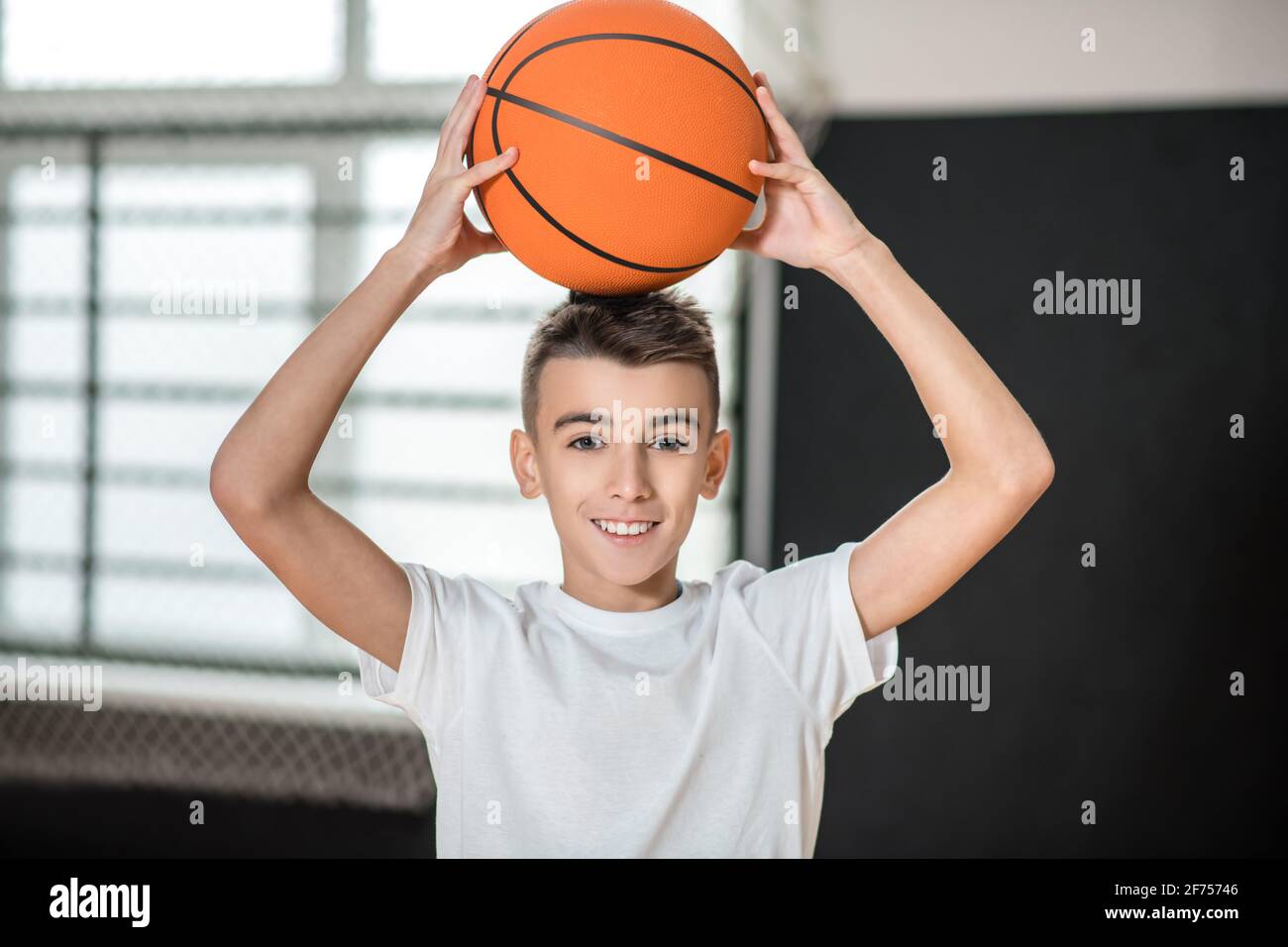 A cute boy with a ball feeling good and contented Stock Photo - Alamy