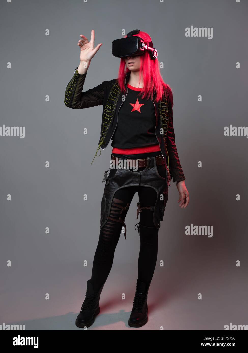 Games and virtual reality, a young red-haired woman uses a VR helmet ...