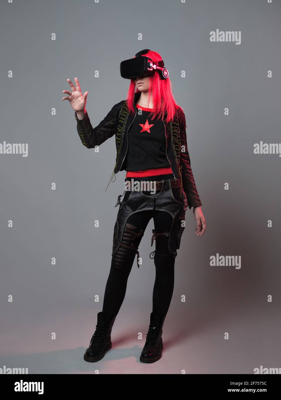 Stylish young gamer in a virtual reality helmet, playing in simulations ...