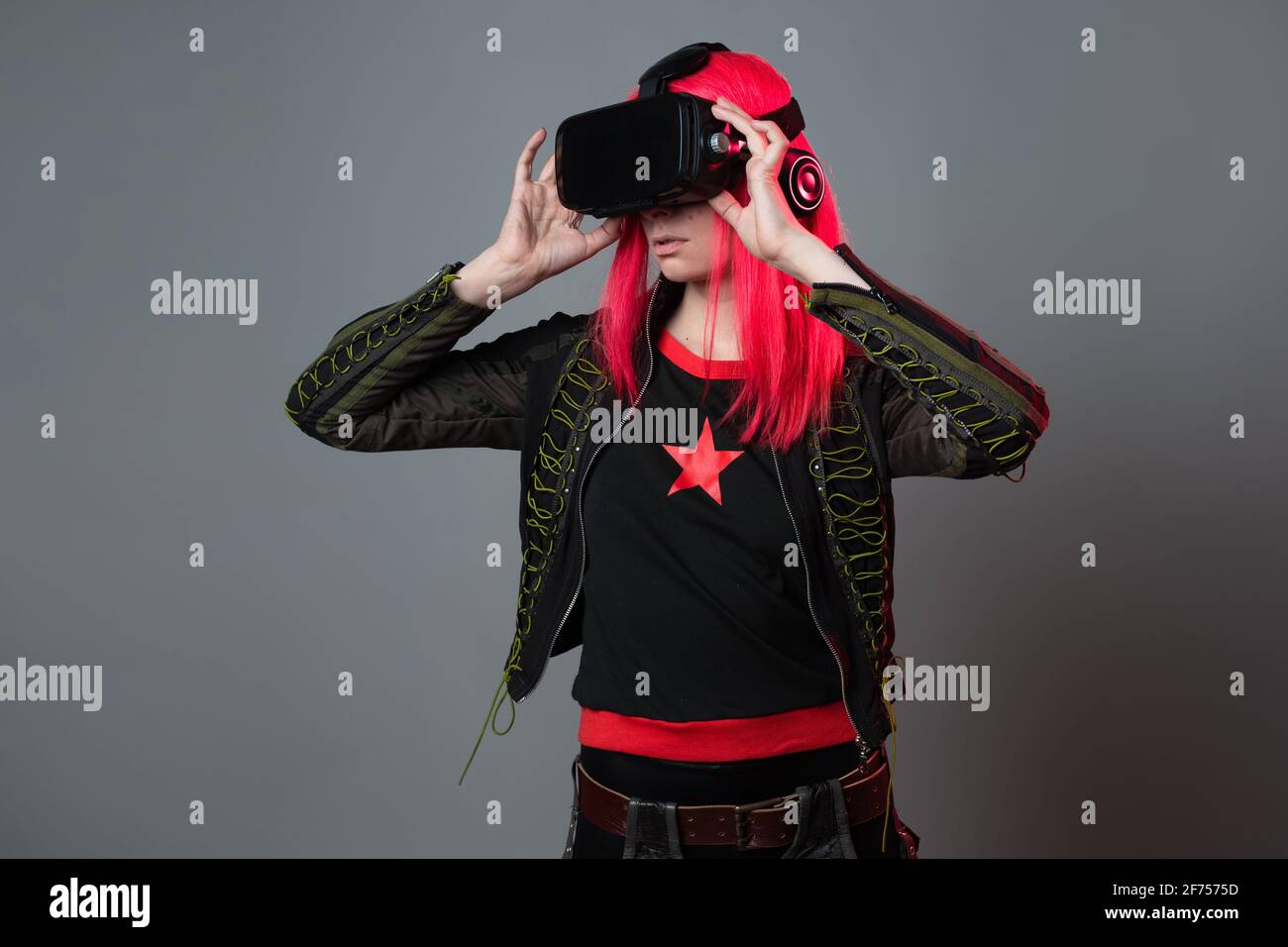 Stylish young gamer in a virtual reality helmet, playing in simulations ...