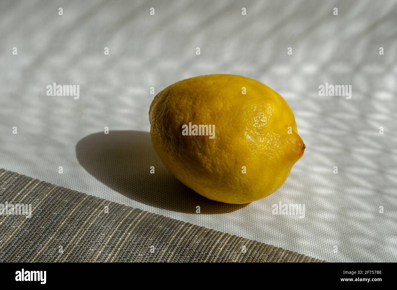 Abstract minimalistic composition with yellow lemon in soft rays of ...