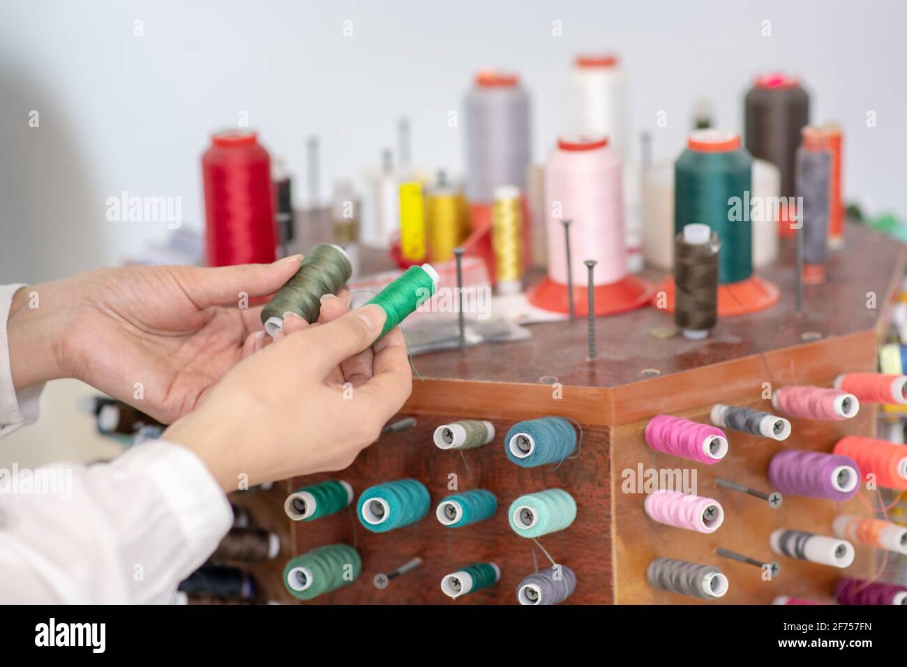 Female hands holding two skeins of thread Stock Photo - Alamy