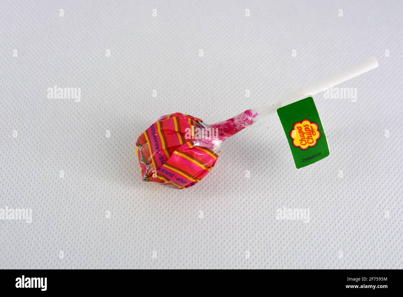 Delicious round sweet candy, white pink lollipop on white plastic stick ...