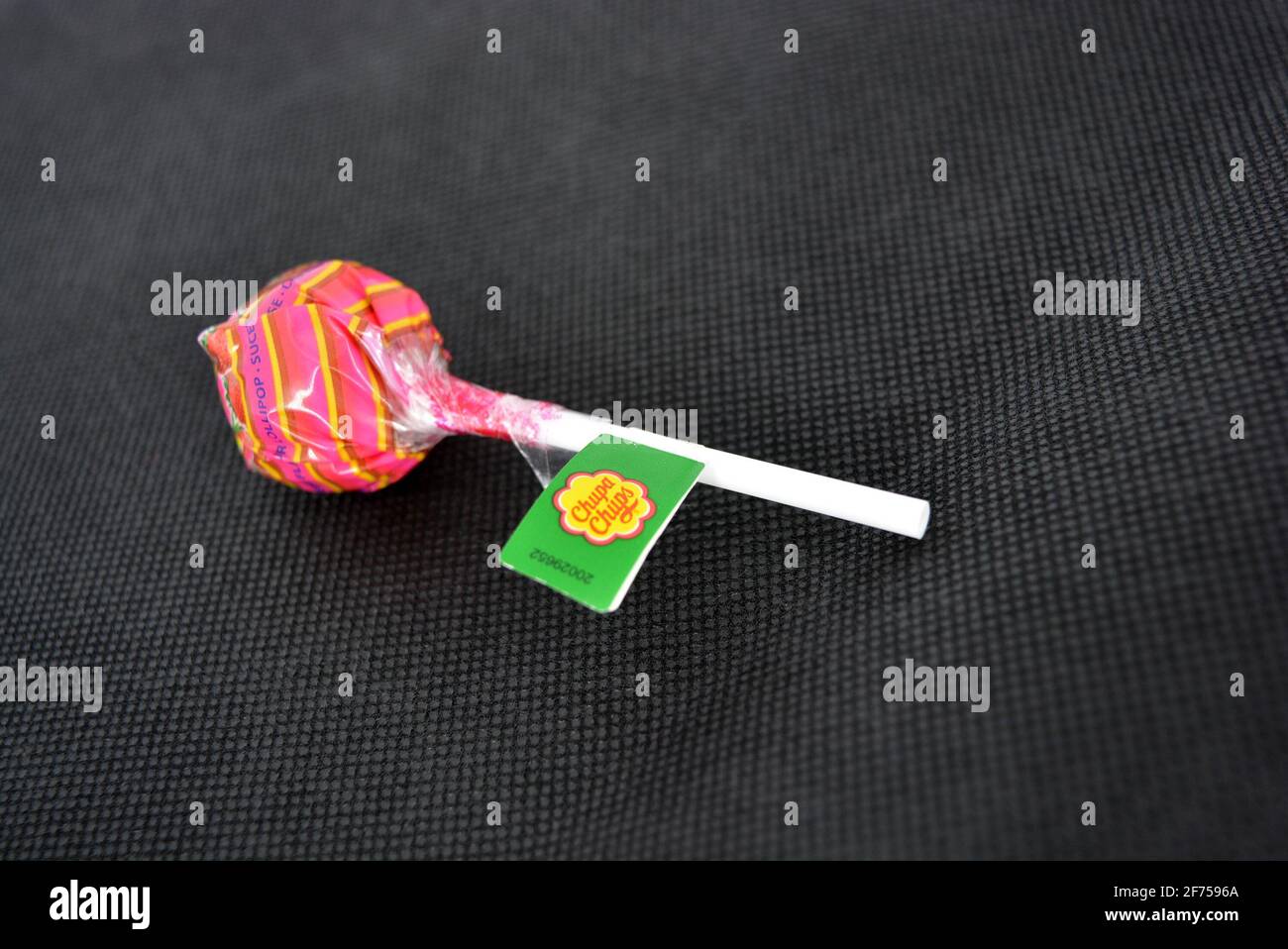 Delicious round sweet candy, white pink lollipop on white plastic stick ...