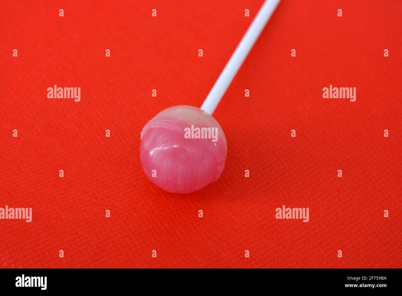 Delicious round sweet candy, white pink lollipop on white plastic stick ...