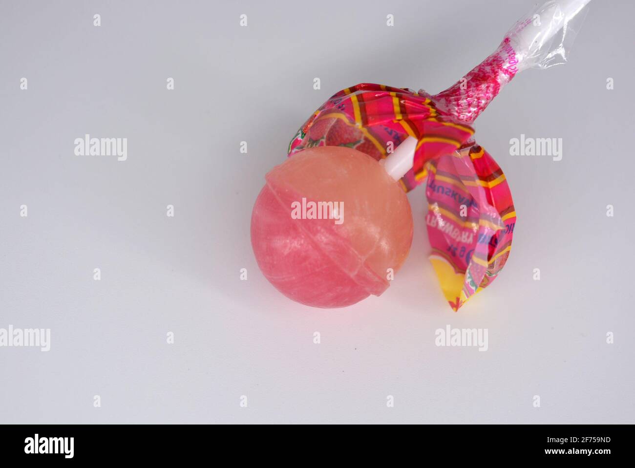 Delicious round sweet candy, white pink lollipop on white plastic stick ...