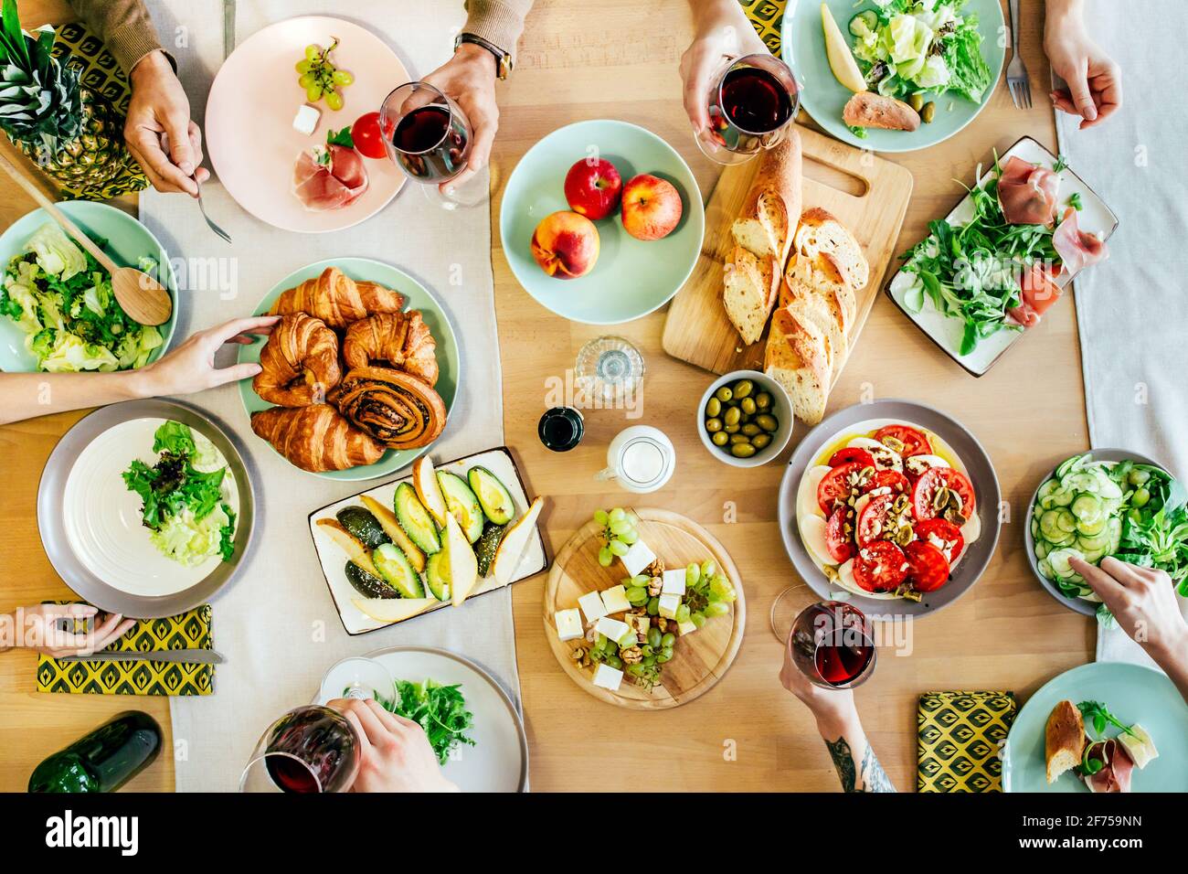 top view of the feast of people at the table covered with food and ...