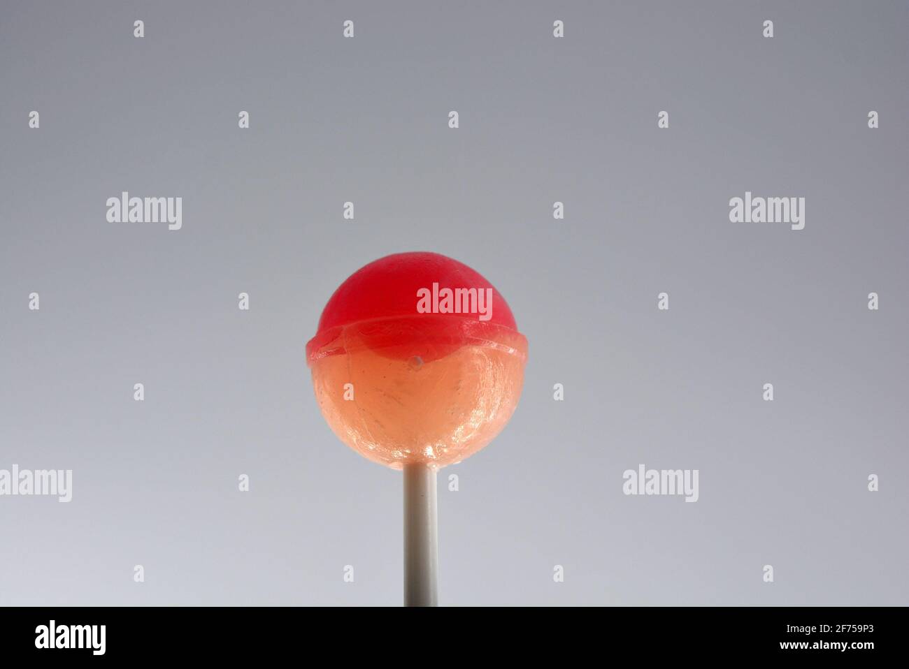 Delicious round sweet candy, white pink lollipop on white plastic stick ...