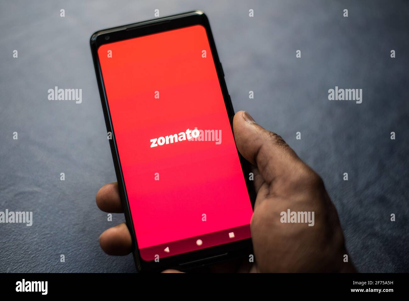 Zomato food delivery app on android smartphone help by asian adult man ...
