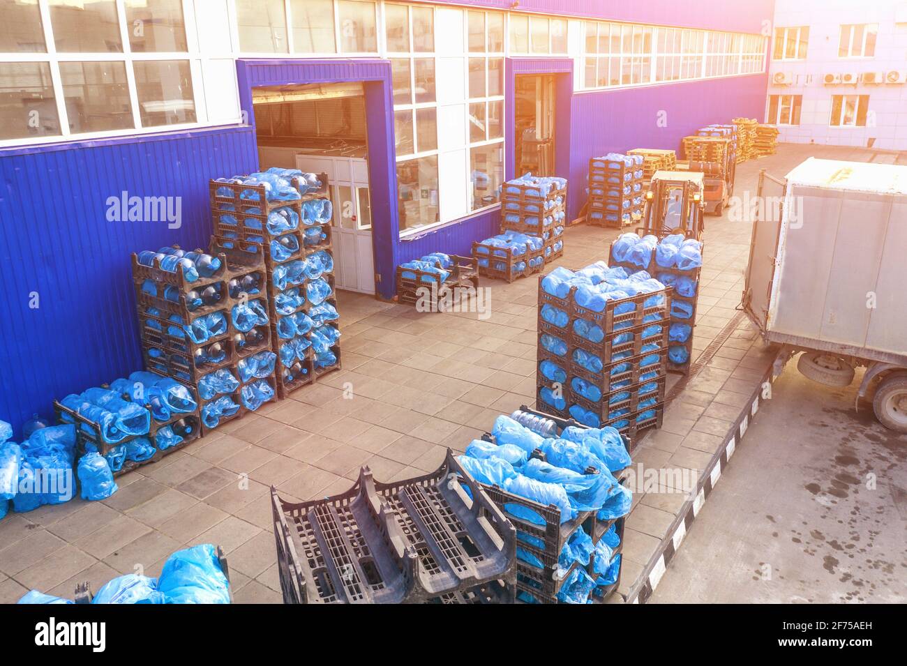 Warehouse with open gates and goods in pallets ready for loading and ...