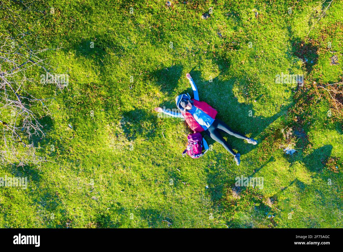 Aerial view of a young woman hiker lying on his back on a meadow Stock ...