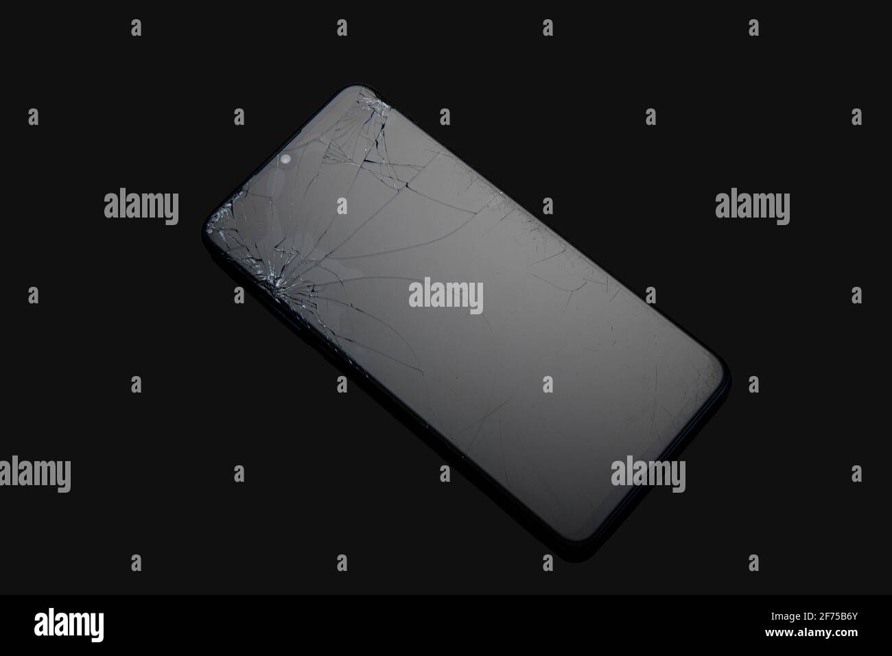 Modern touchscreen smartphone with broken screen on dark background ...