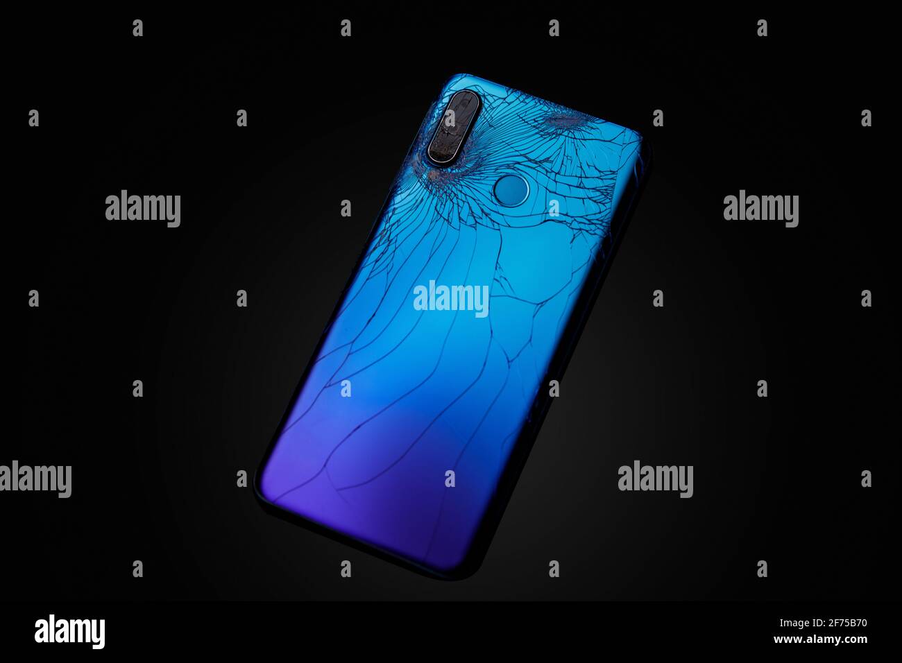 The back panel of a broken mobile phone. Damaged smartphone camera ...