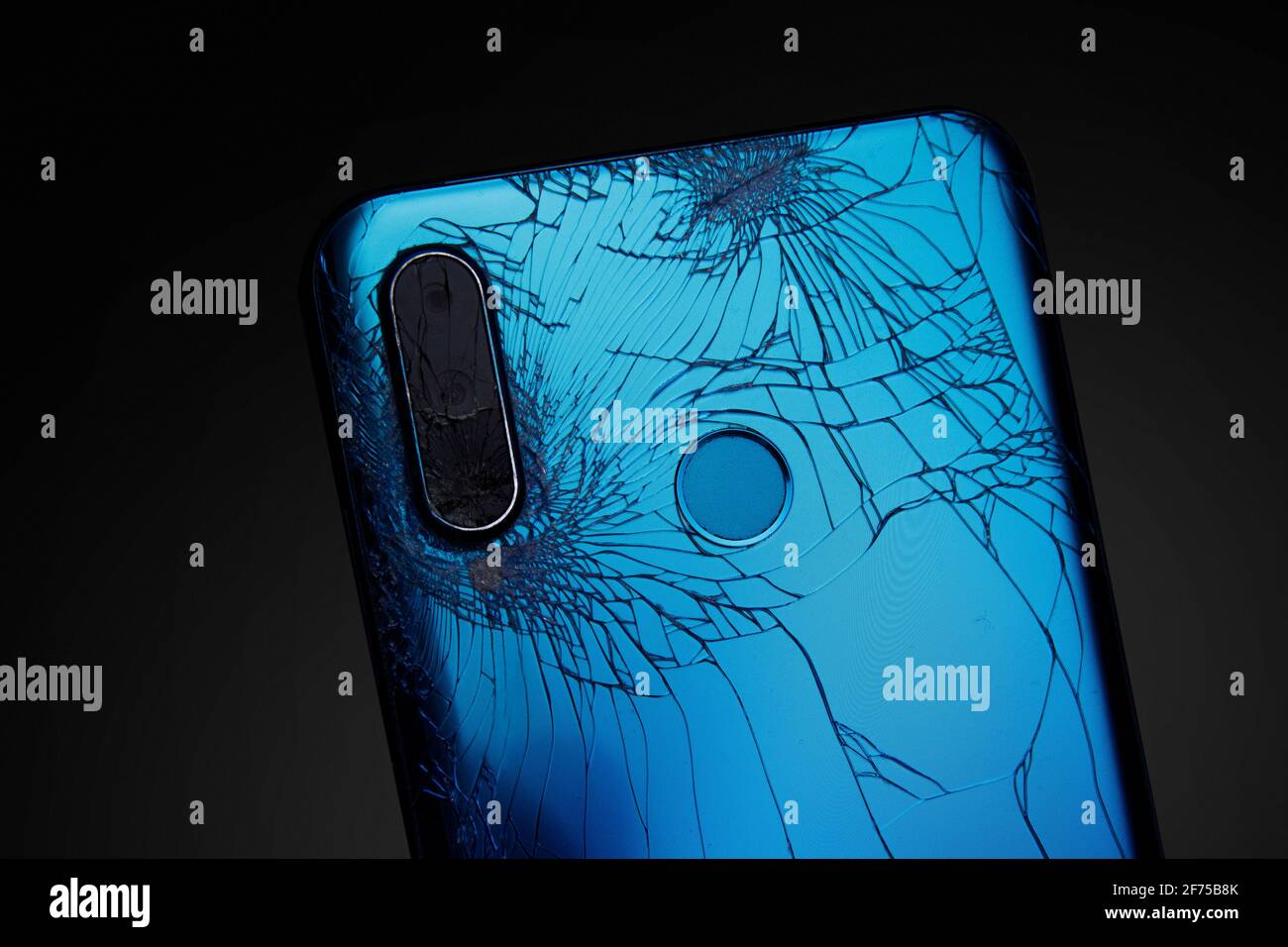 The back panel of a broken mobile phone. Damaged smartphone camera ...
