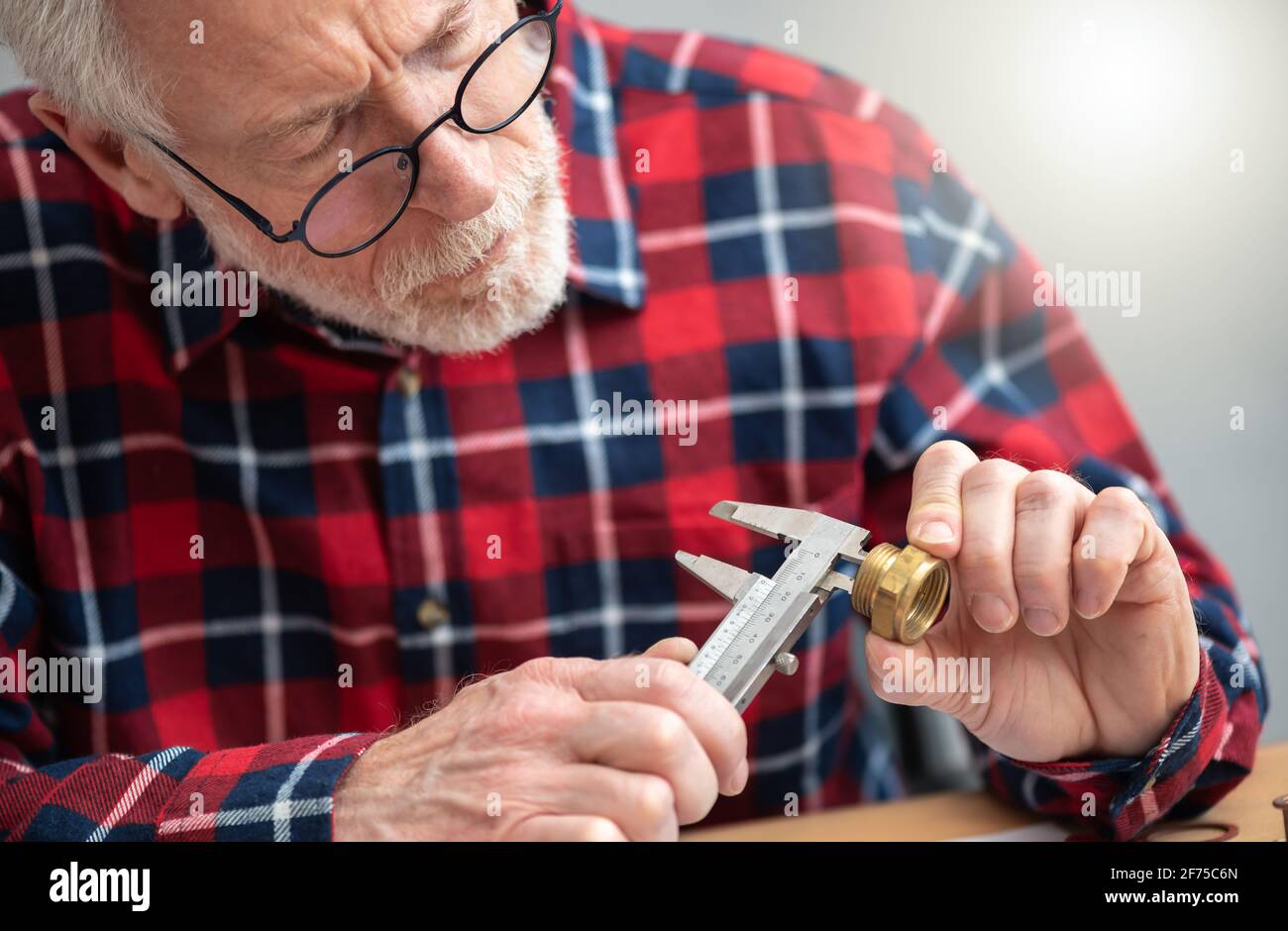 Plumber measuring a plumbing fitting with a caliper Stock Photo - Alamy