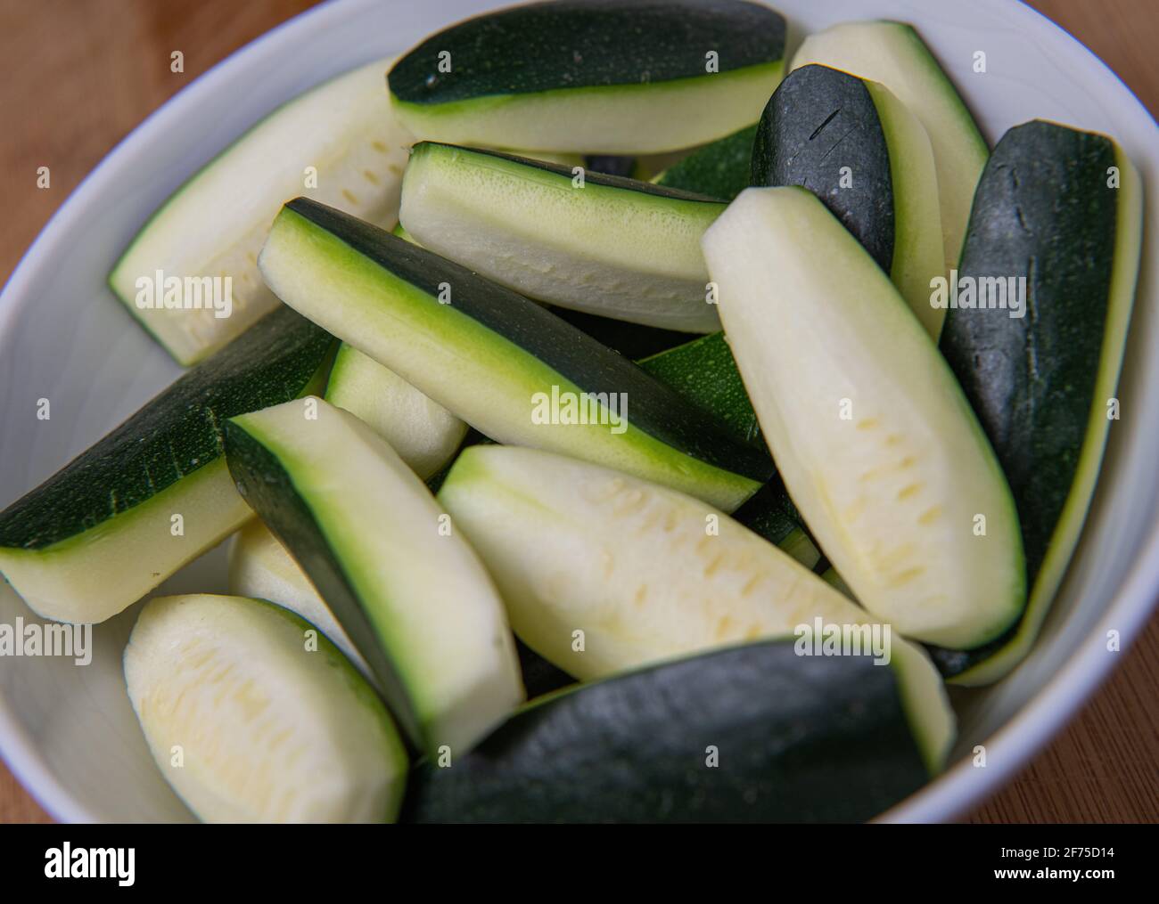 Preparing fresh courgette, zucchini on wood table Stock Photo - Alamy