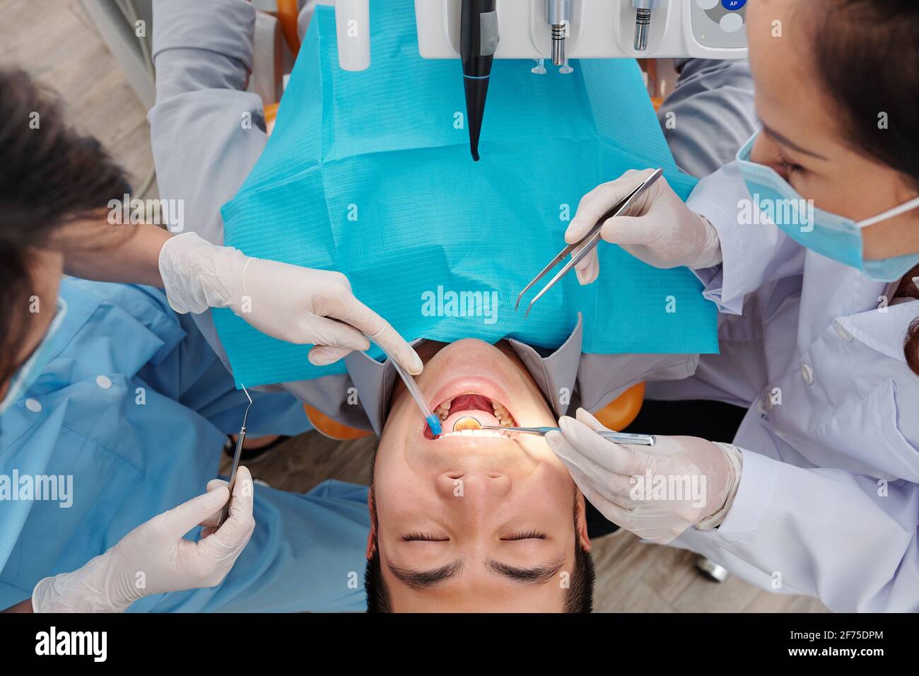 Patient sitting in dental chair with his mouth wide open when dentist ...