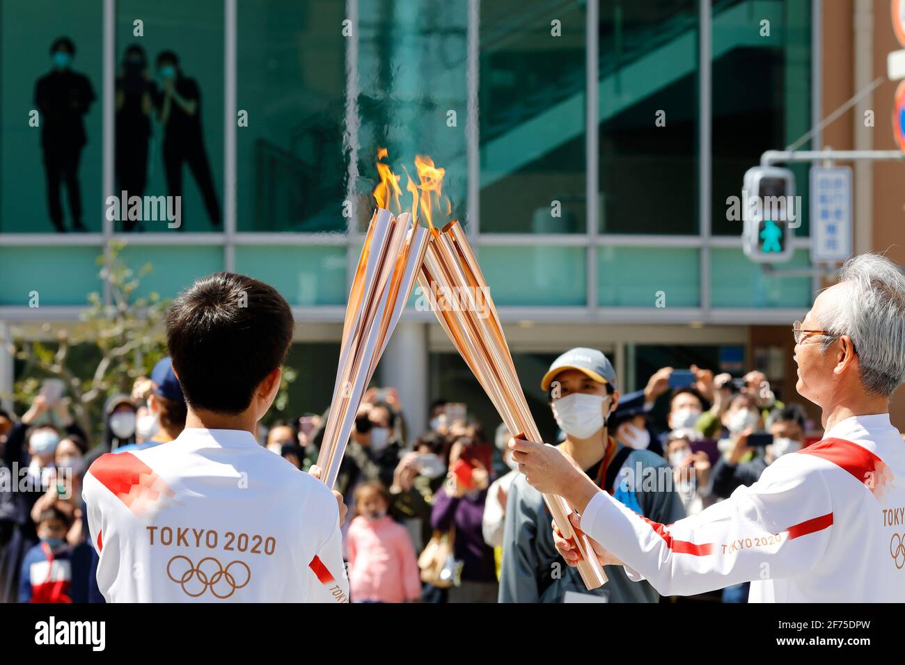 Local torchbearers pass the Olympic flame during the Tokyo 2020 Olympic ...