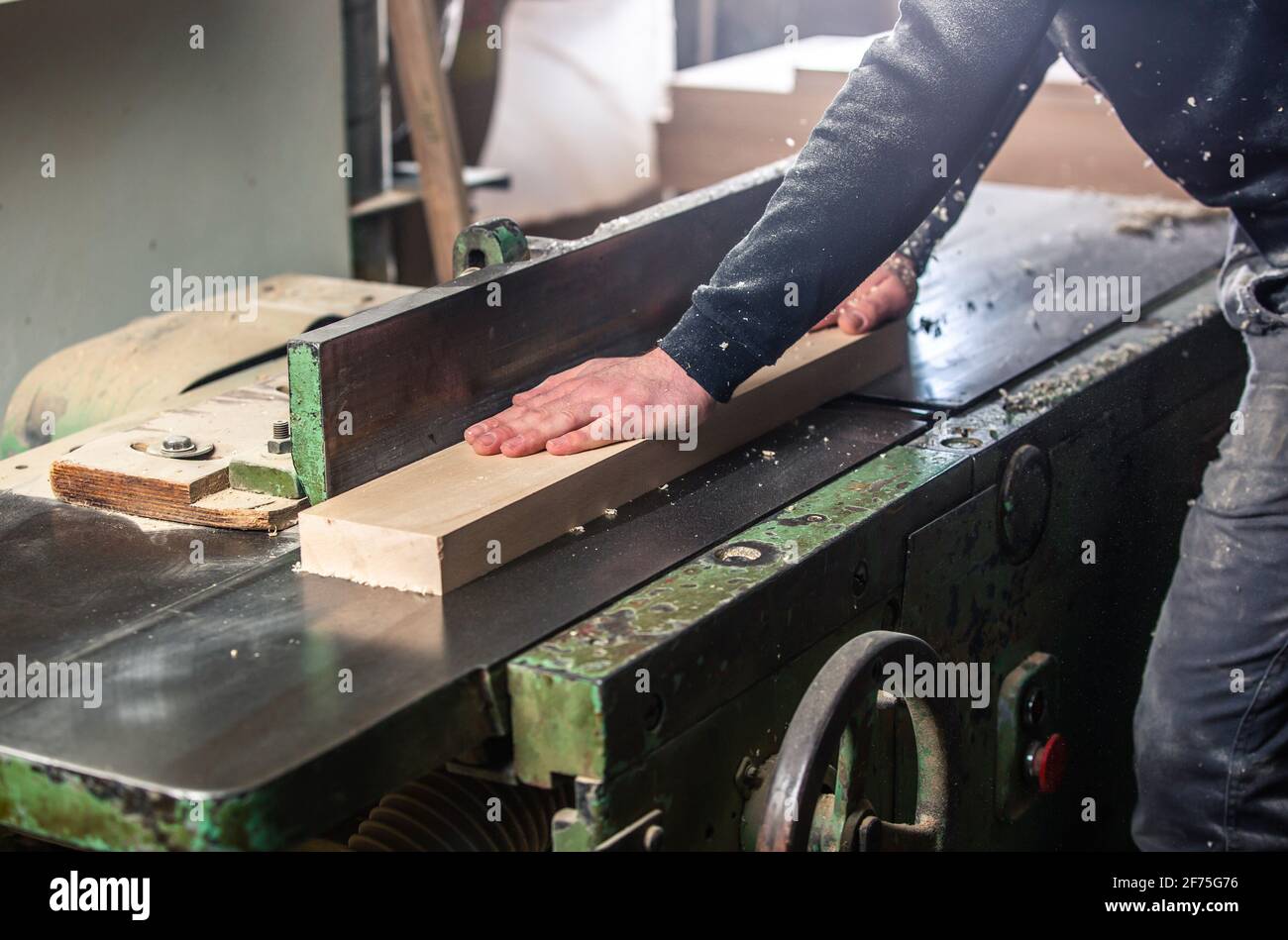 Carpenter working on woodworking saw machines in carpentry shop ...