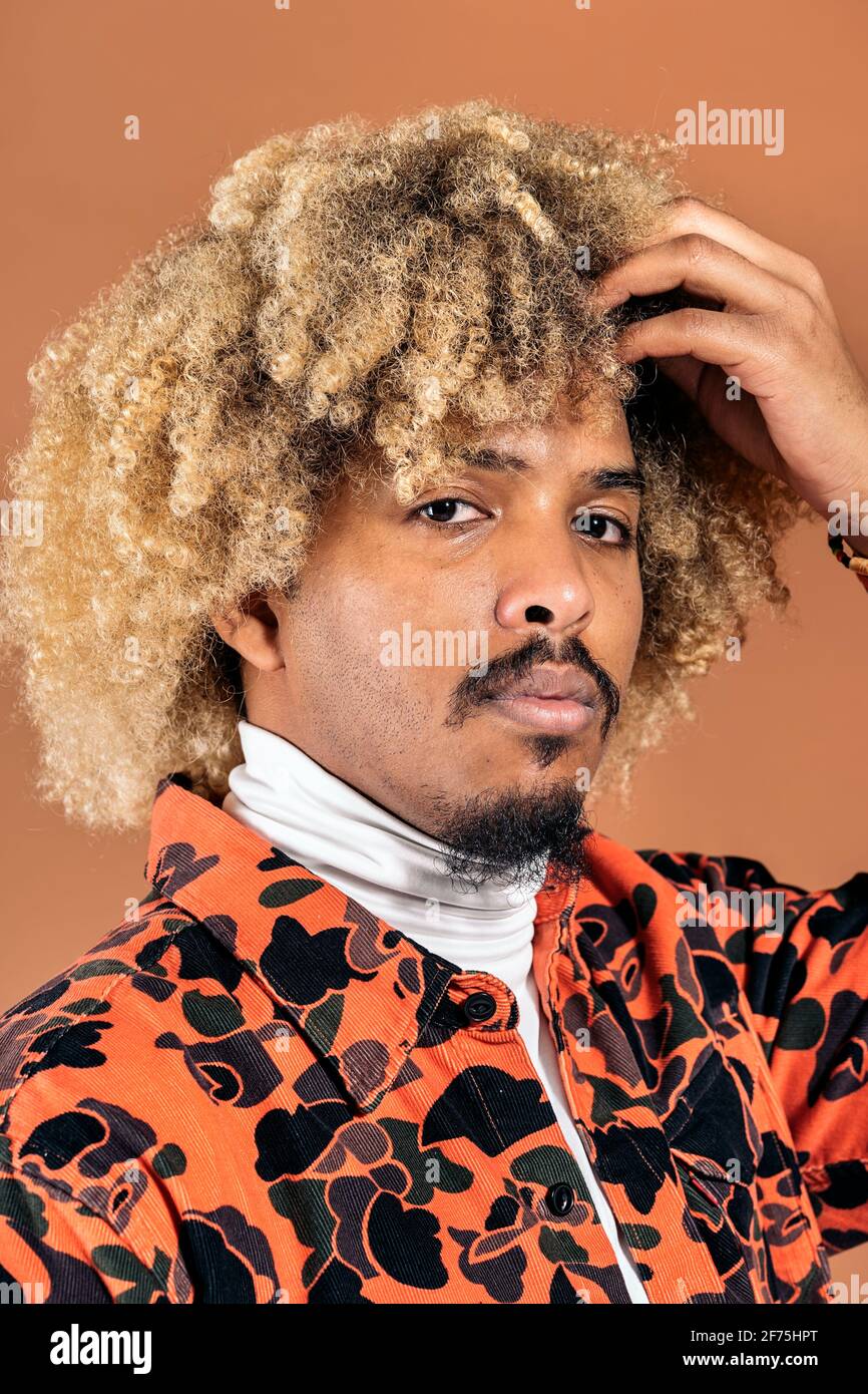 Stock photo of cool afro man posing and looking at camera in studio ...