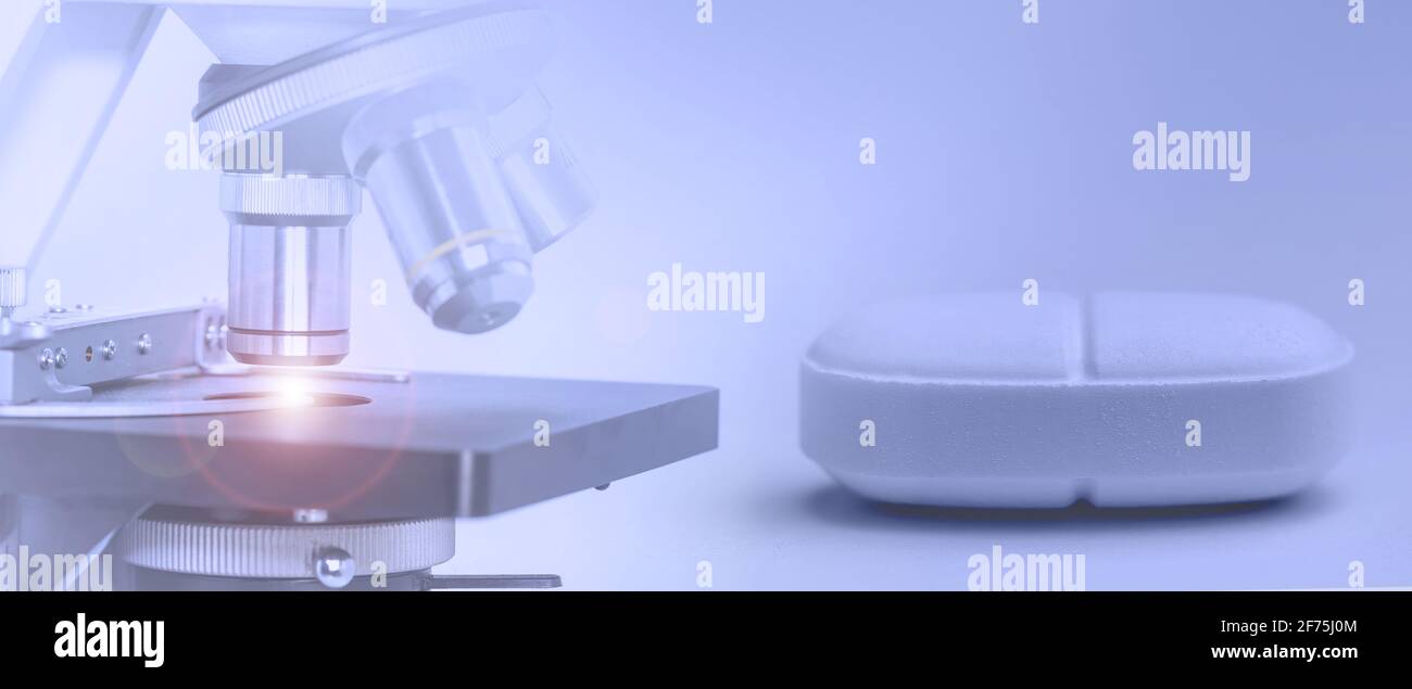 Microscope in labor in with a rug Pill,against blue white background ...