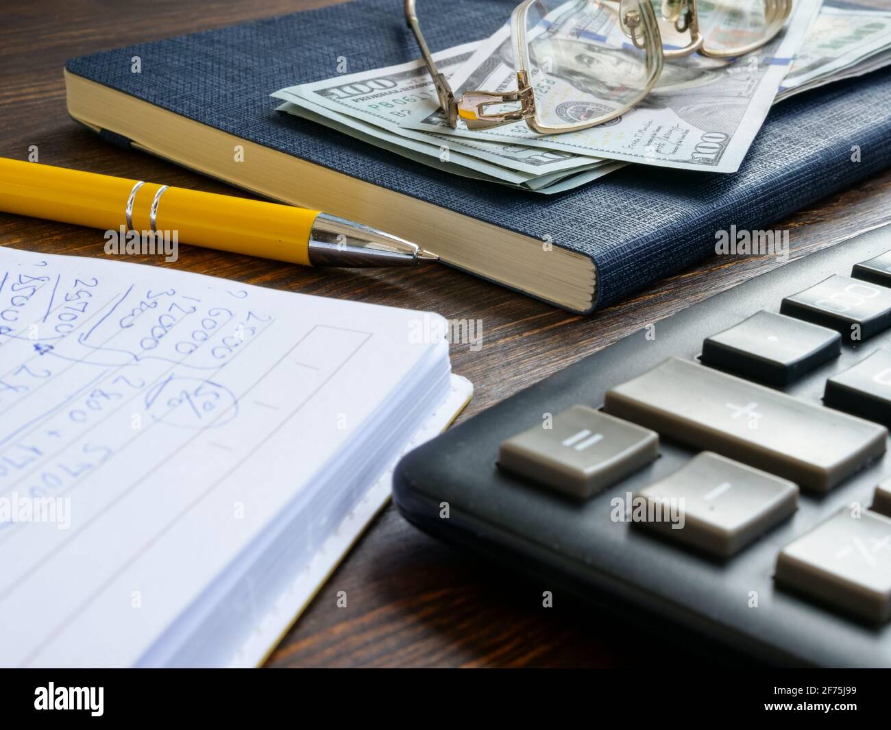 Financial calculations in the notepad, money and calculator Stock Photo ...