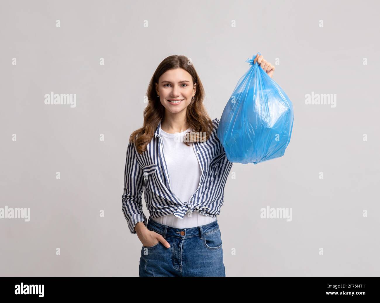 Woman carrying garbage bag hi-res stock photography and images - Alamy
