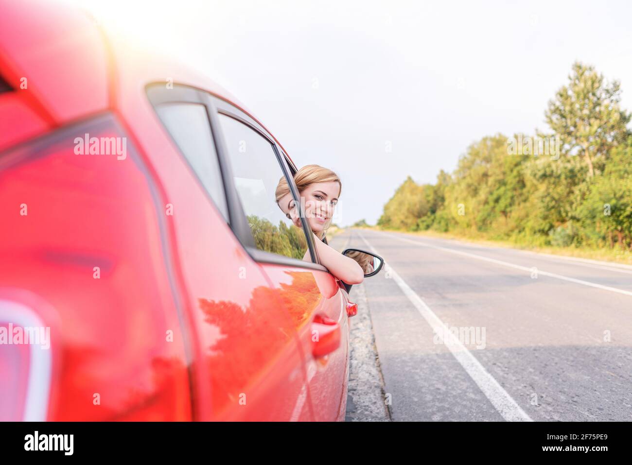 Happy beautiful woman is driving a red car Stock Photo - Alamy