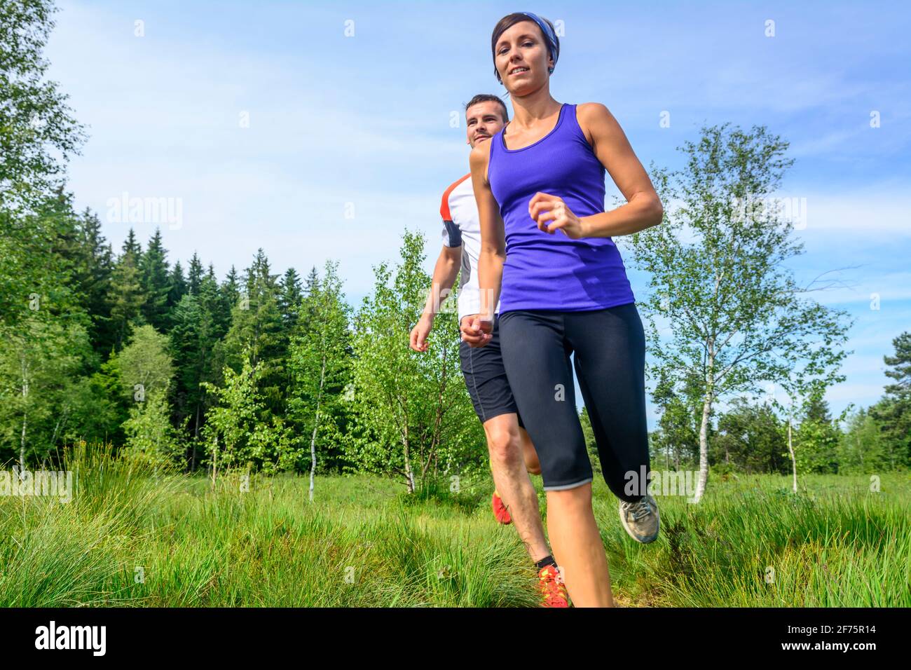 Young people jogging on a forest path, joint-friendly running training ...
