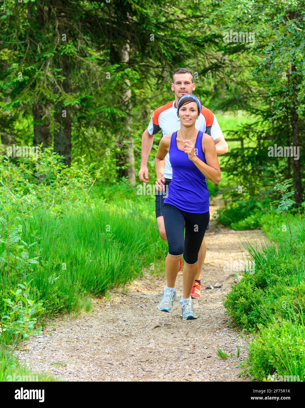 Young people jogging on a forest path, joint-friendly running training ...