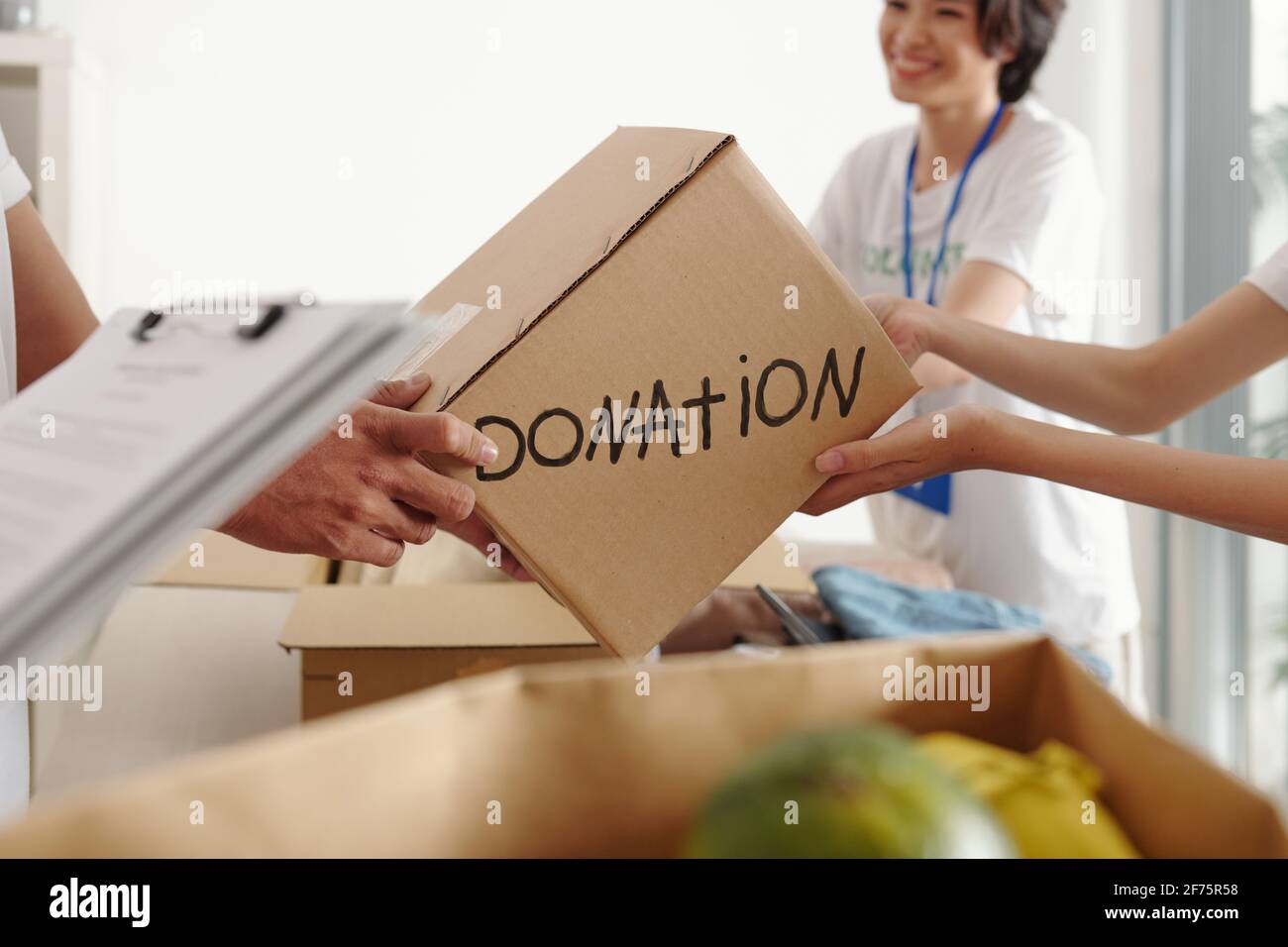 Hands of man giving box with groceries and warm clothes to worker at ...
