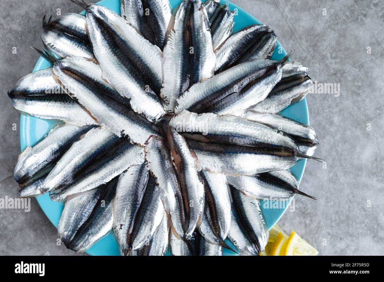 Plate full of headless anchovies. Fresh fish concept Stock Photo - Alamy