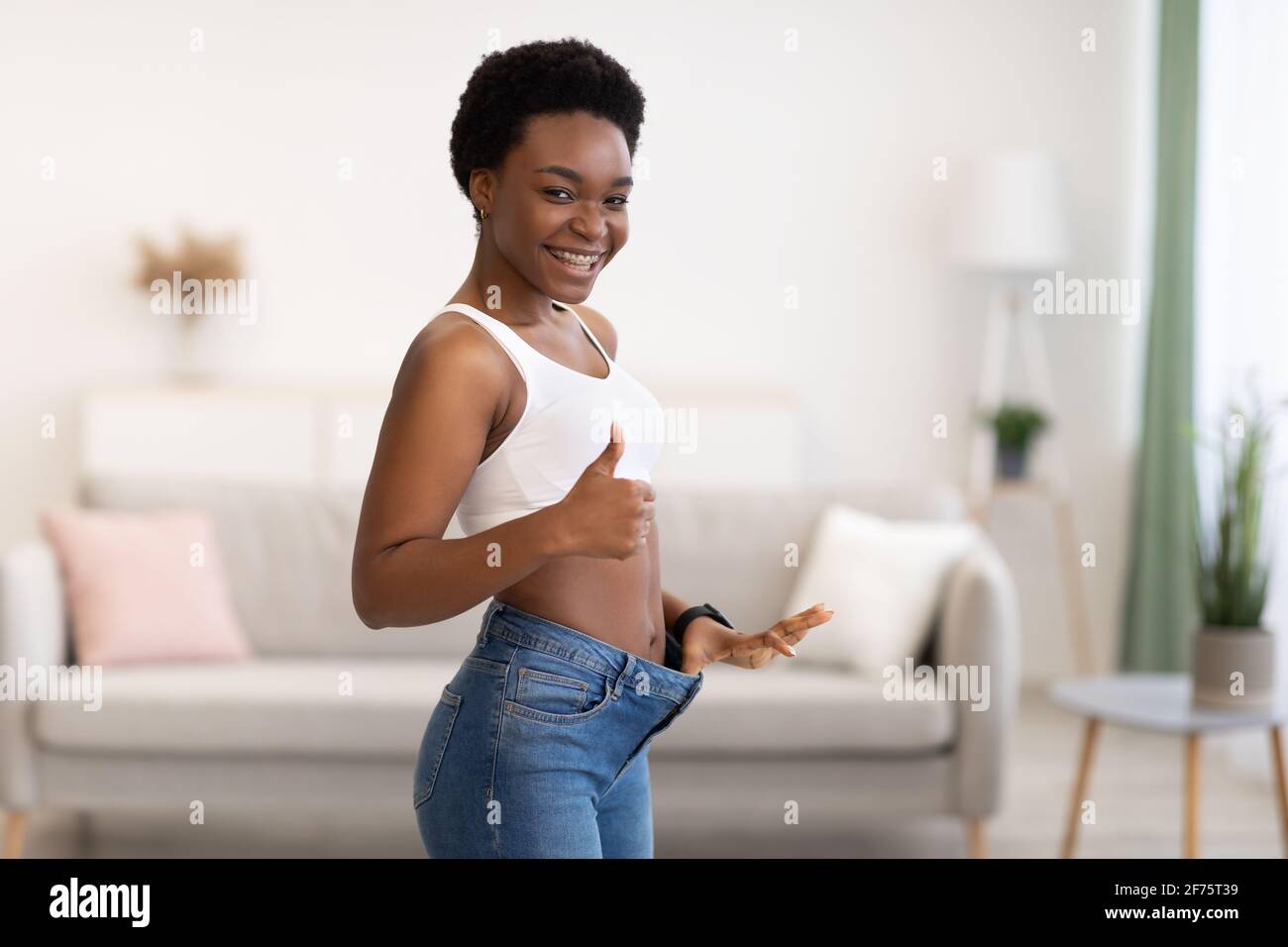 sporty woman showing thumbs up Stock Photo - Alamy