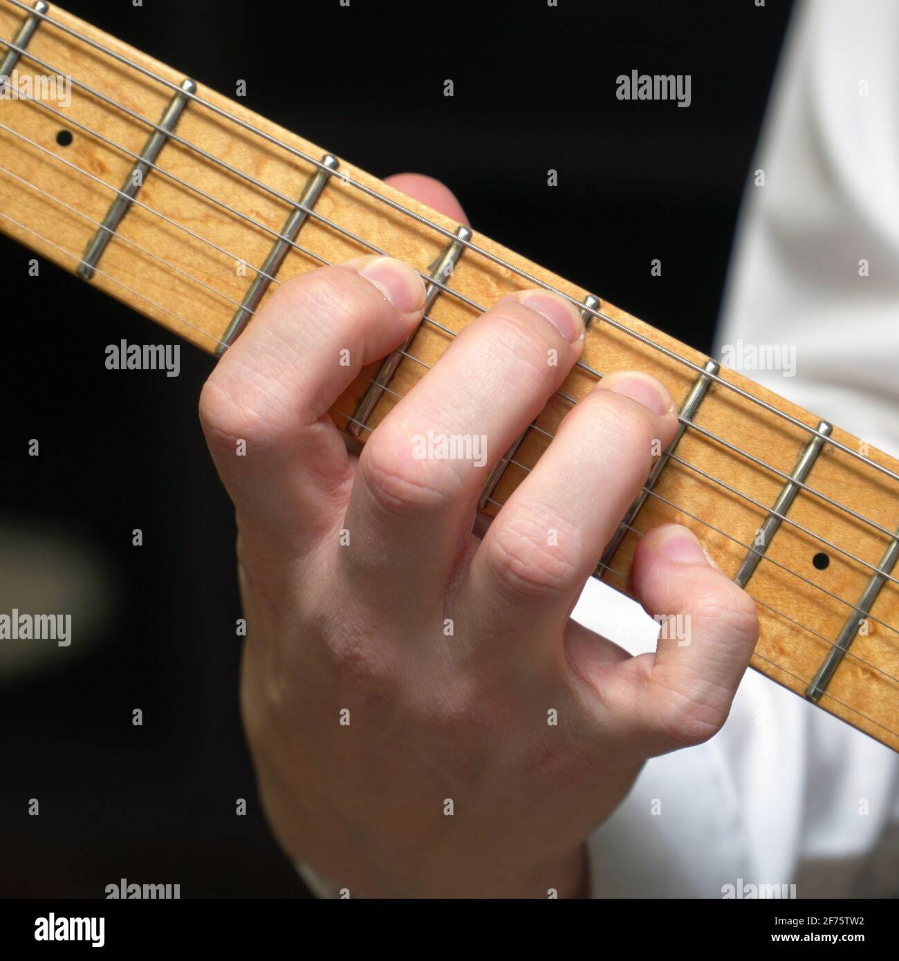 Guitarist's fingers on the neck of a six-string electric guitar Stock ...
