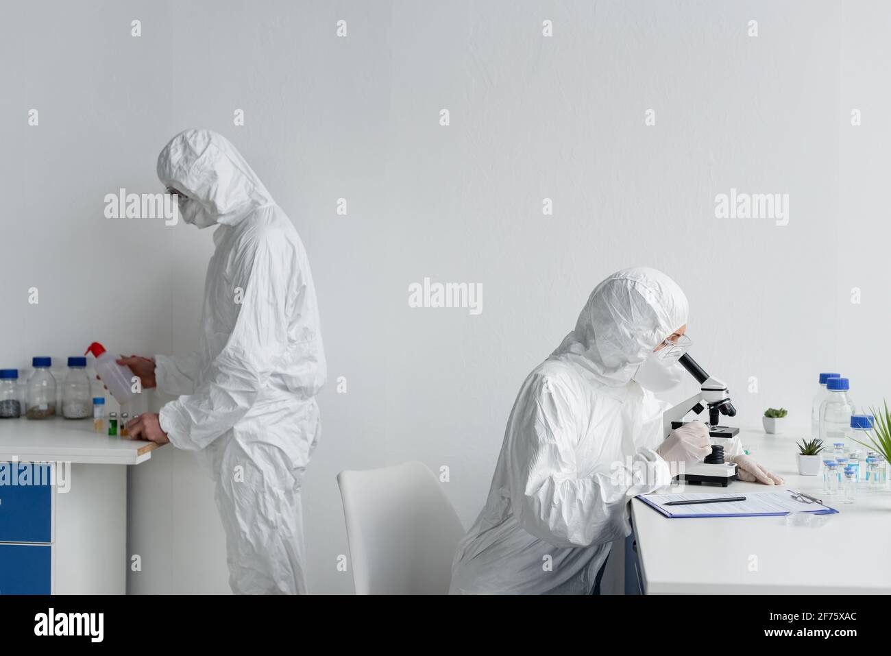 Scientists in hazmat suits working with vaccines in laboratory Stock ...