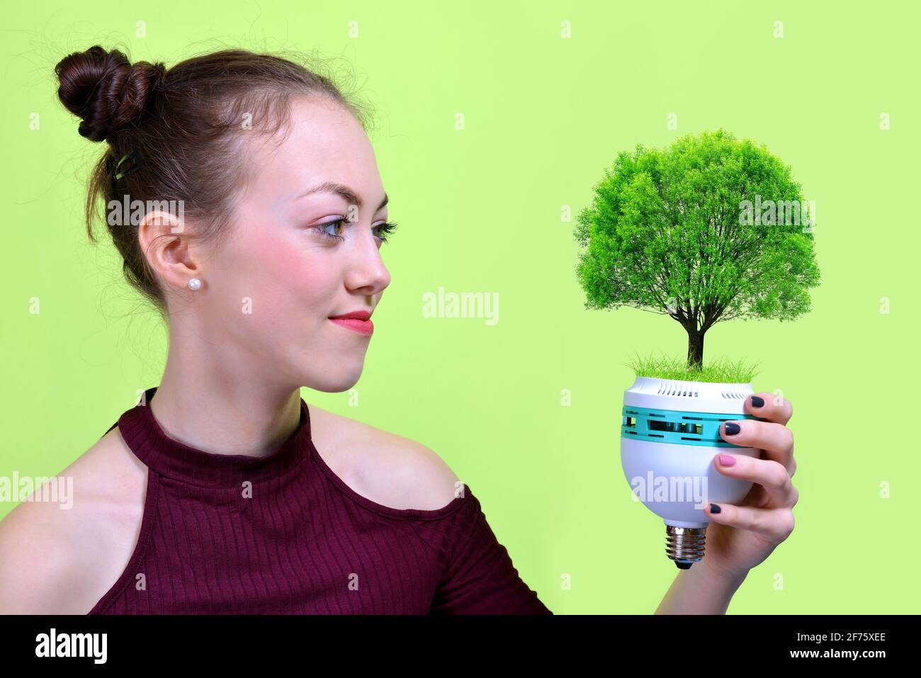 Girl holding eco bulb with tree in hand. Green energy concept Stock ...