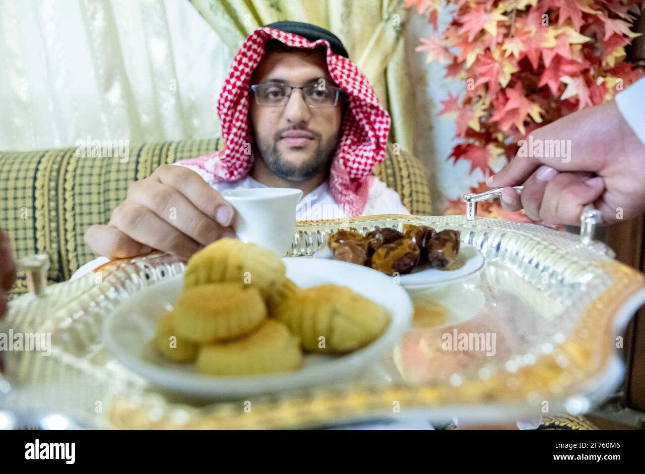 Arabic man serving coffee Stock Photo - Alamy