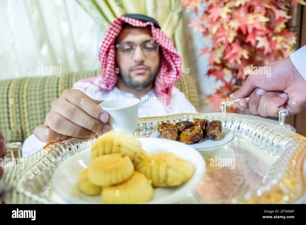 Arabic man serving coffee Stock Photo - Alamy