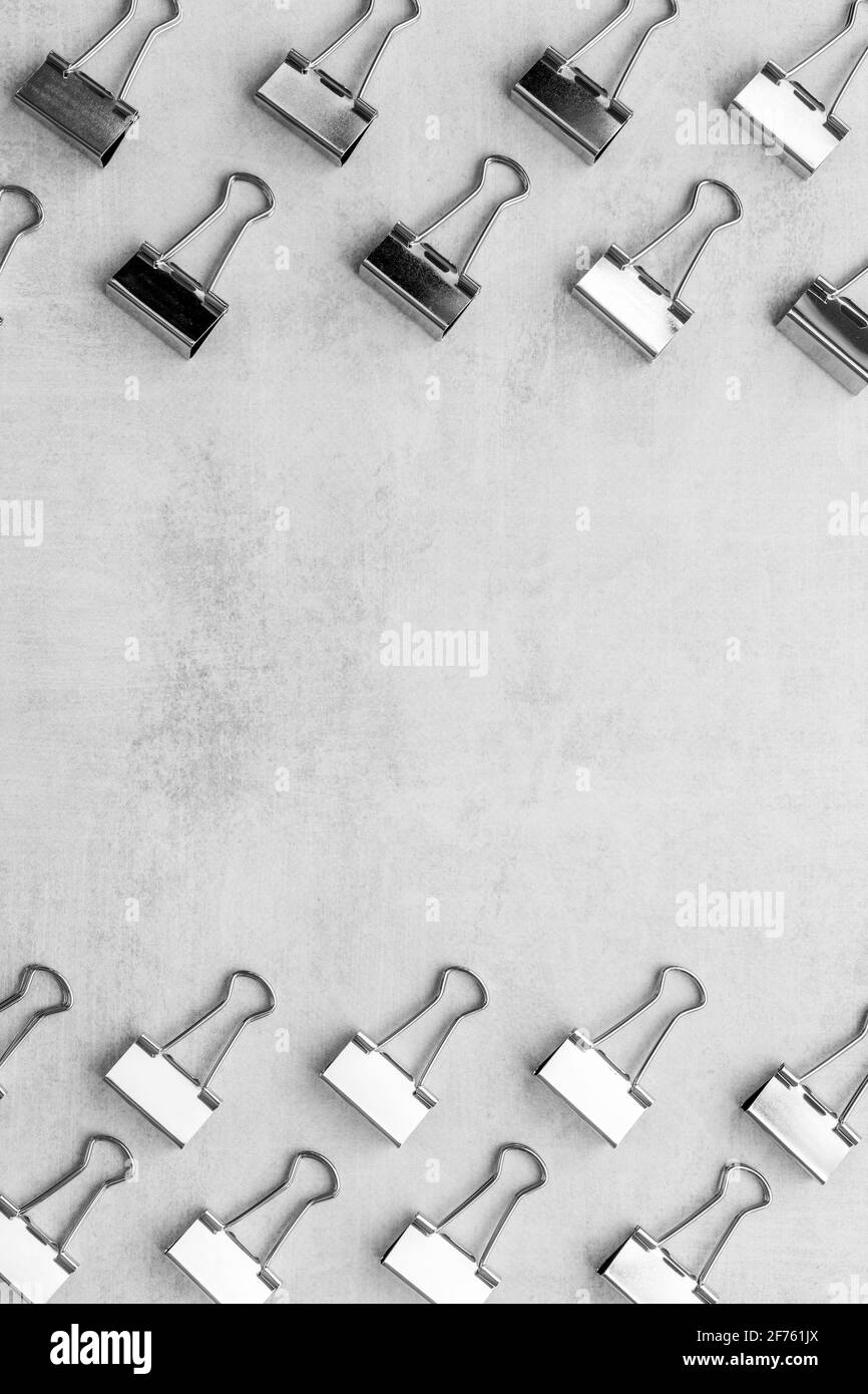 Frame of silver paper binder clips top view. Office supplies pattern ...