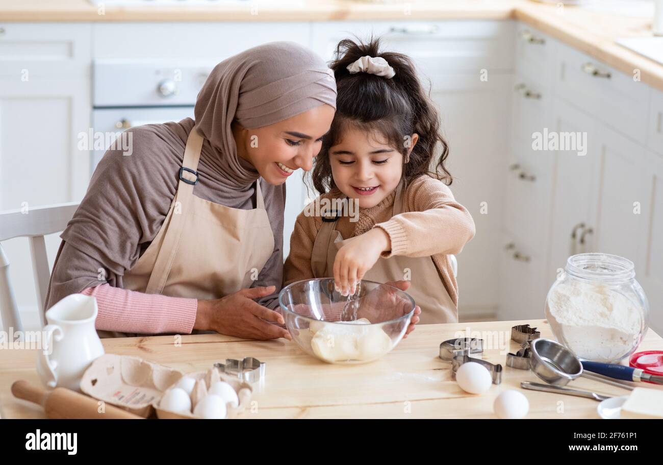 Cute Little Arab Girl Helping Her Muslim Mom In Kitchen, Baking ...