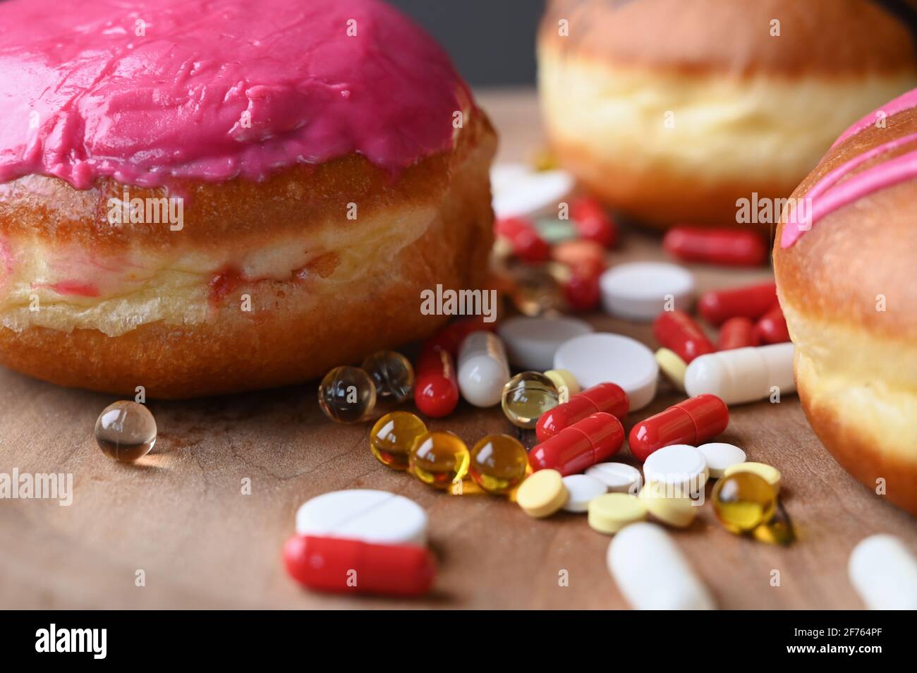 Close up of donuts and pills. Junk food and medical tablets. Unhealthy ...