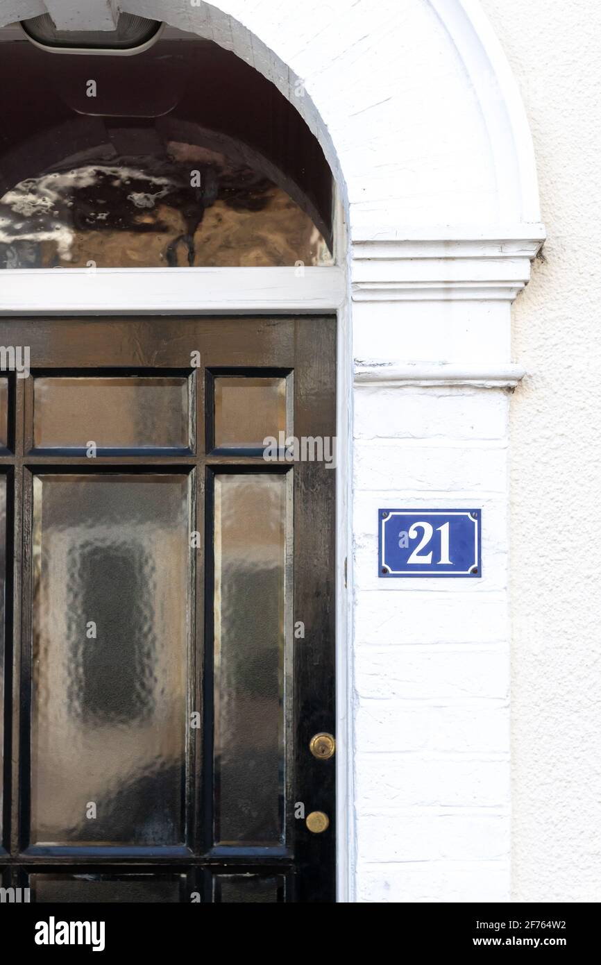 House number 21 next to a recessed blacck front door Stock Photo - Alamy