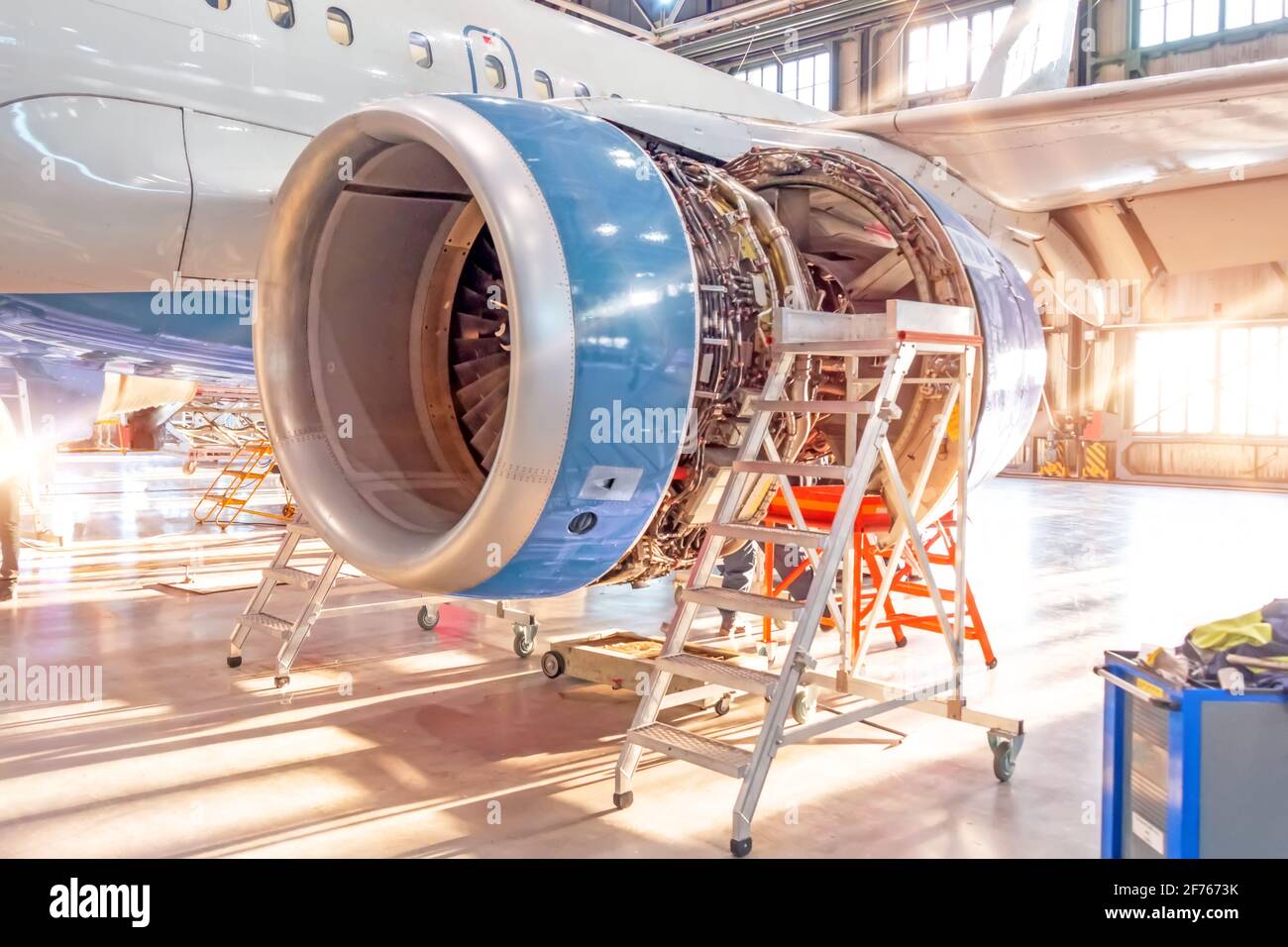 Opened aircraft engine in the hangar, illuminated by bright sunlight ...